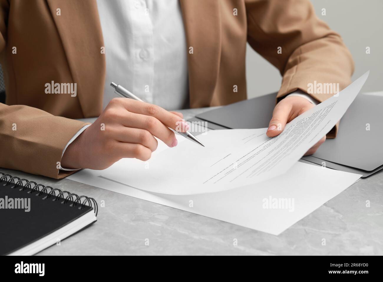 Woman signing document at light grey marble table, closeup Stock Photo ...