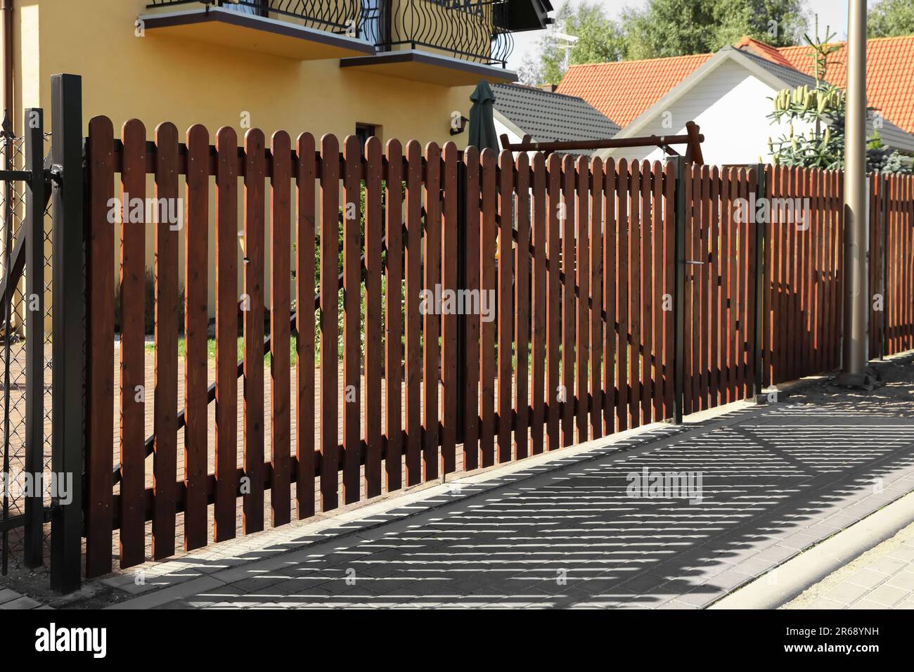 Closed wooden gates near beautiful houses outdoors Stock Photo - Alamy