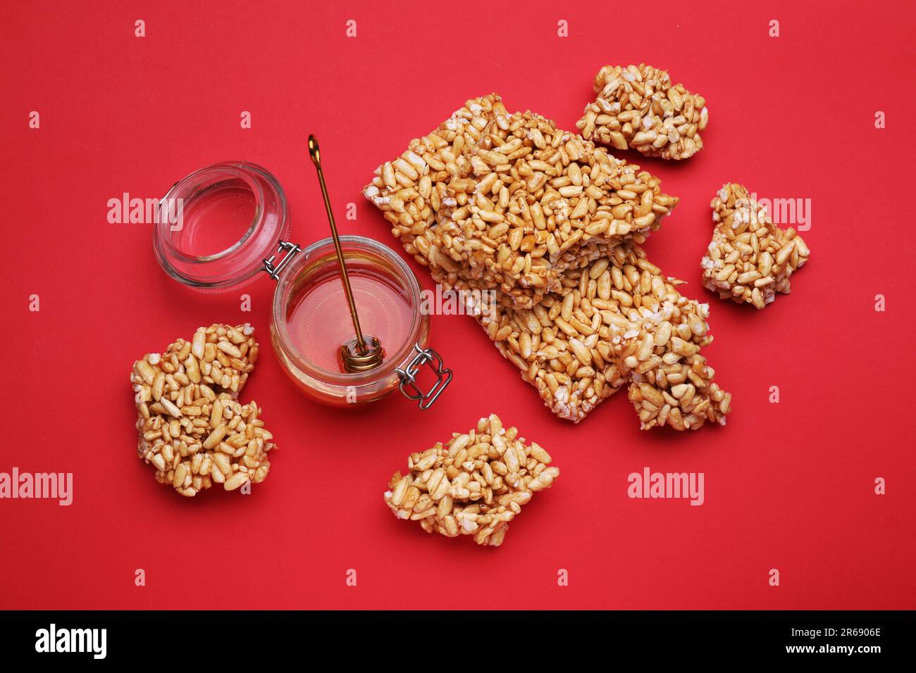 Puffed rice bars (kozinaki) and honey on red background, flat lay Stock ...
