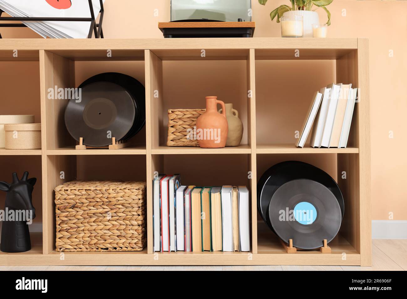 Wooden shelving unit with vinyl records near beige wall indoors Stock ...