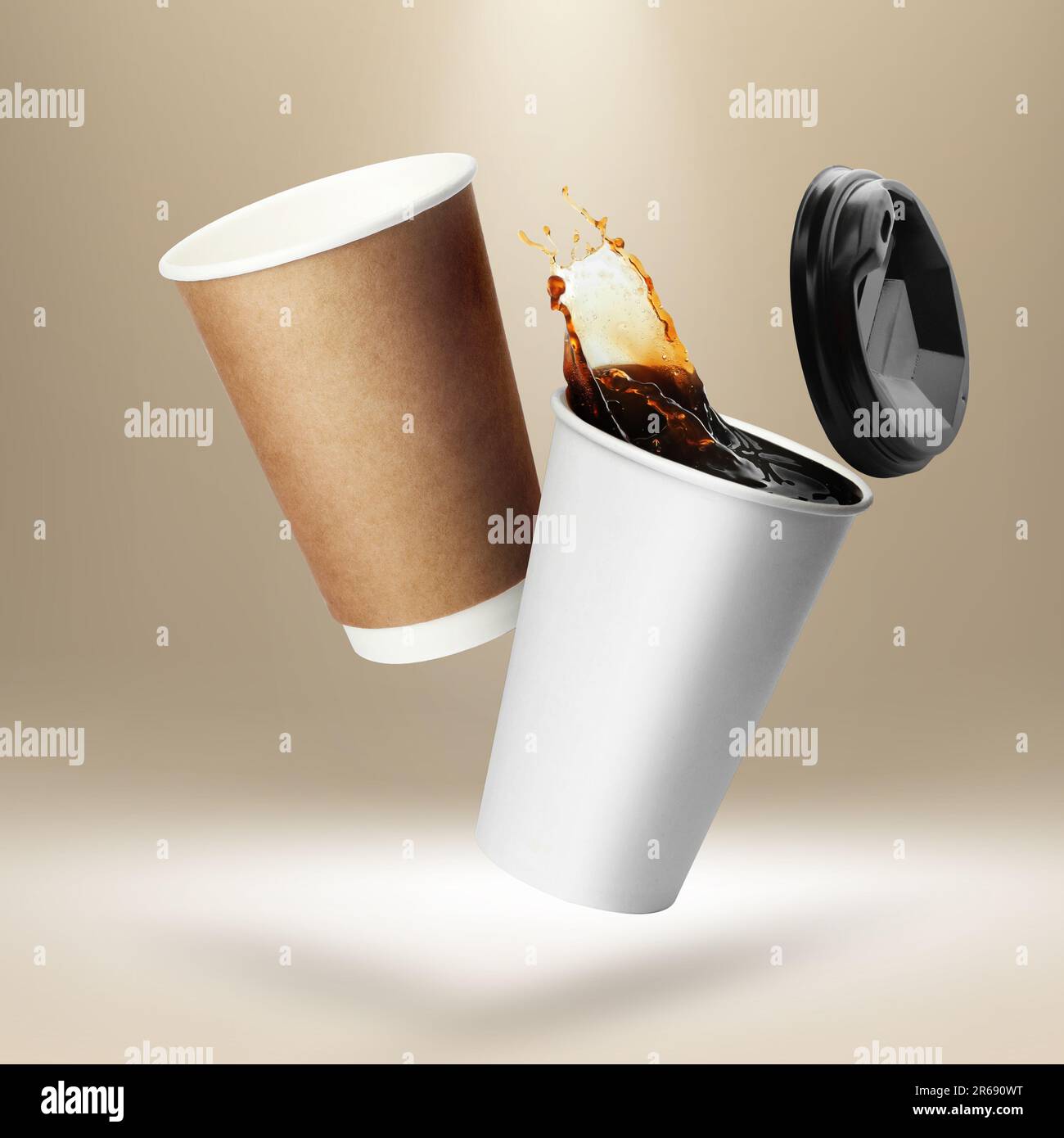 Takeaway paper cups falling on beige background Stock Photo - Alamy