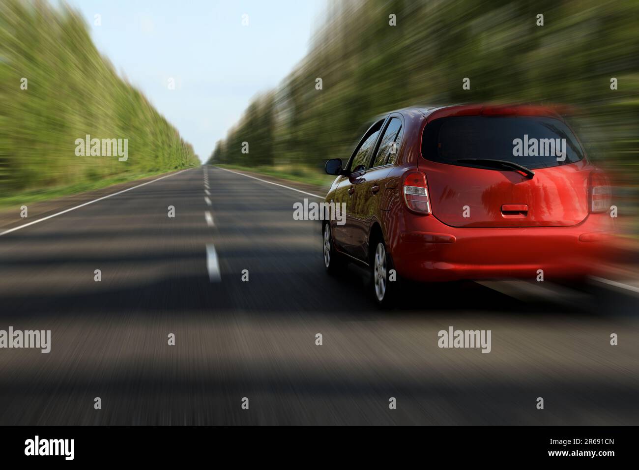 Red car driving at high speed on asphalt road outdoors, motion blur ...
