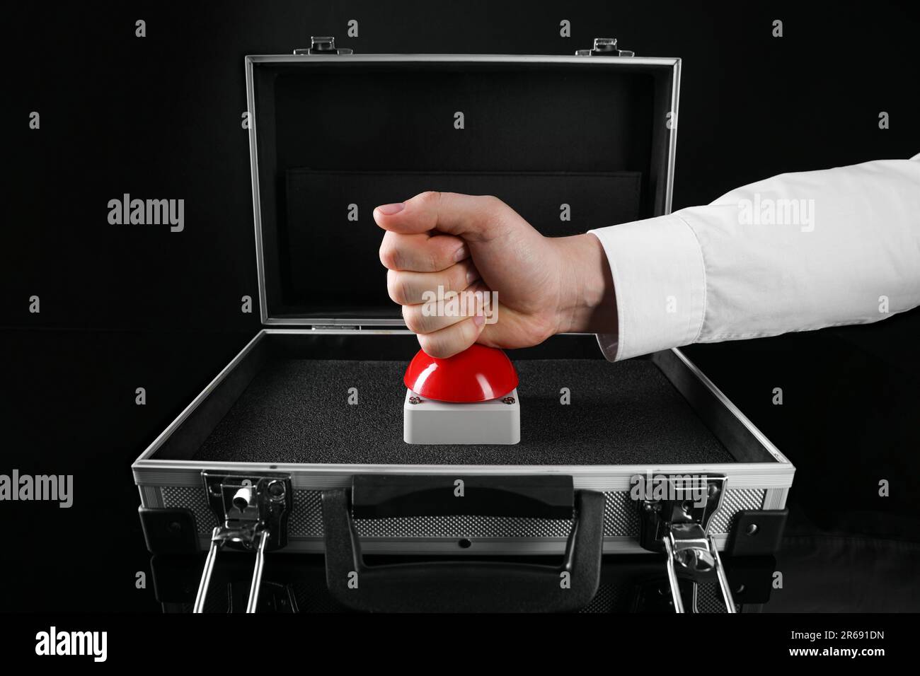 Man pressing red button of nuclear weapon on black background, closeup ...