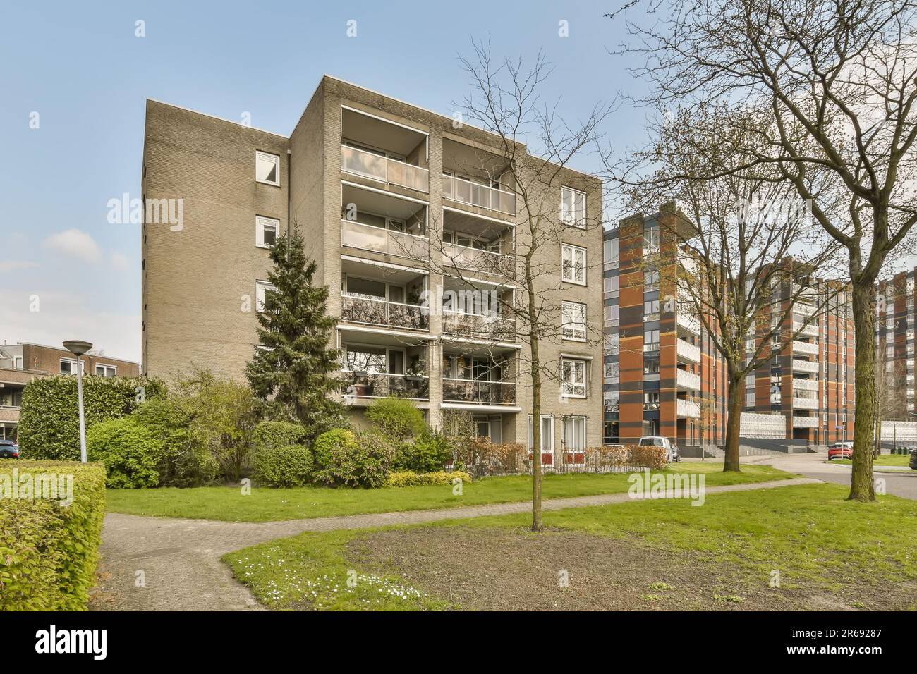 an apartment complex in the city with trees and grass on either side ...