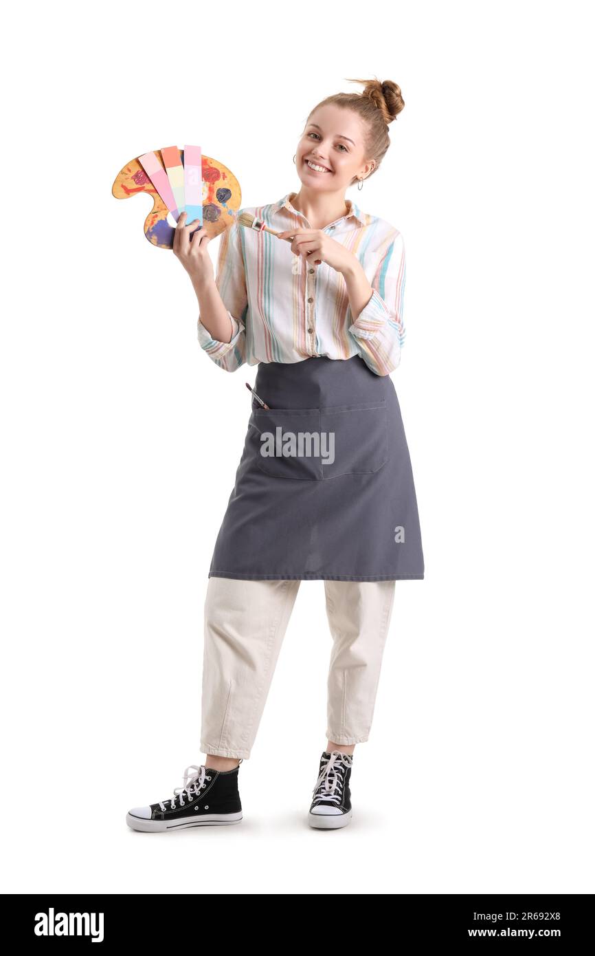 Female artist with brush pointing at color samples and paint palette on ...