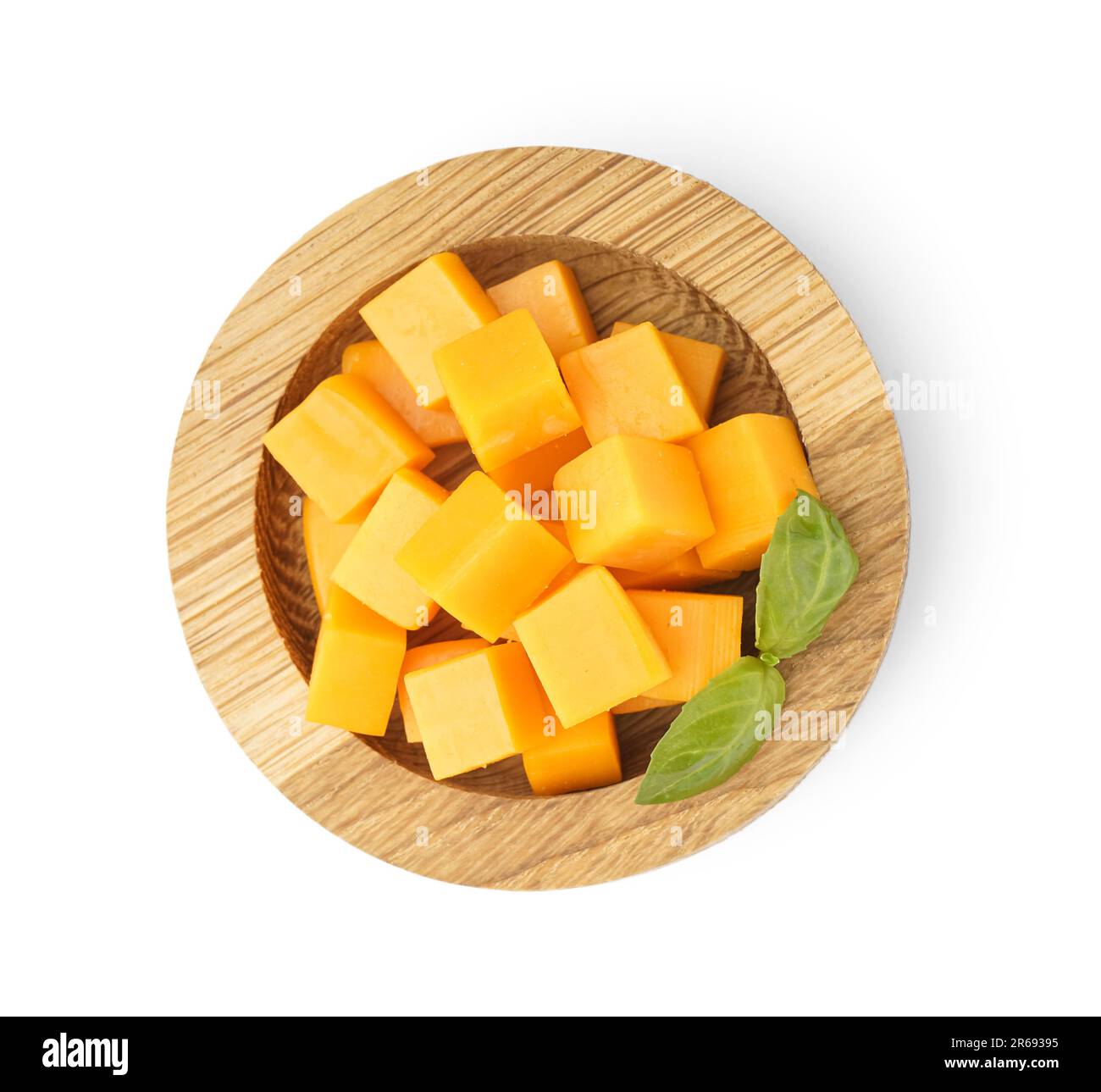 Wooden bowl with cubes of tasty cheddar cheese on white background ...