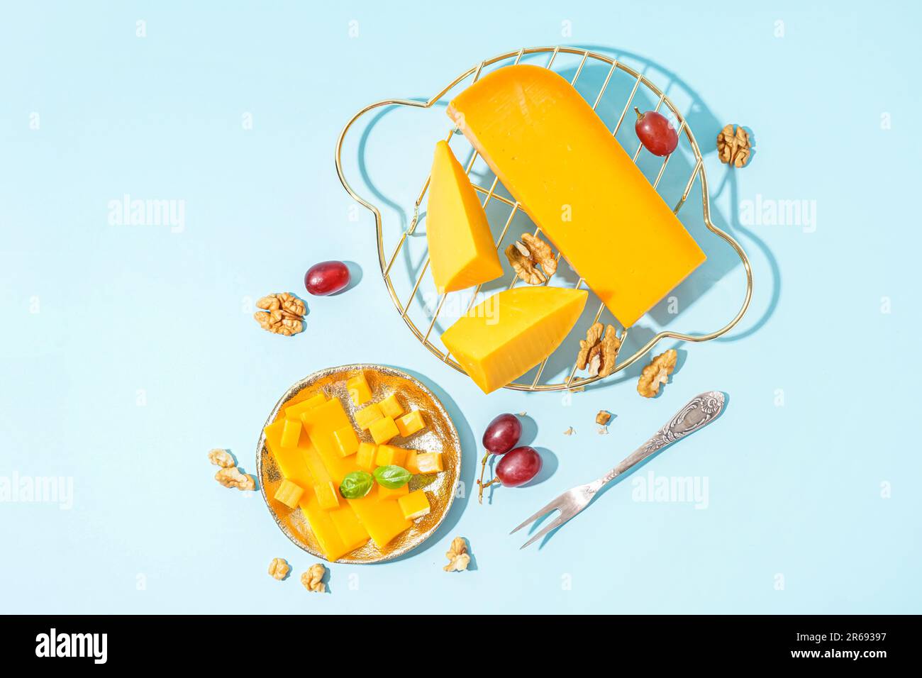 Composition with tasty cheddar cheese, grapes and nuts on blue ...