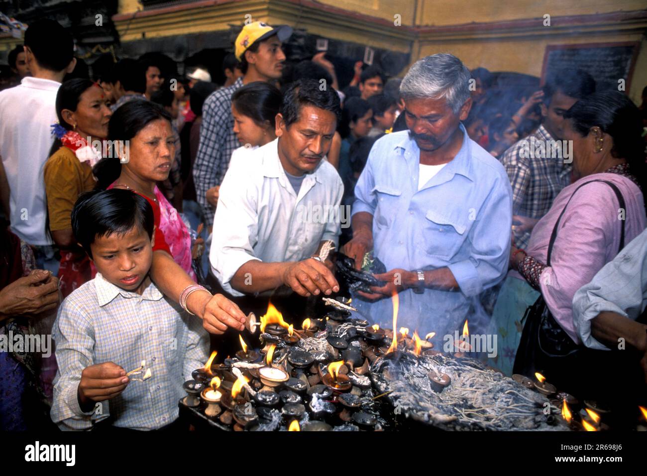 People lighting candle offerings in a Buddhist temple in Cambodia on ...