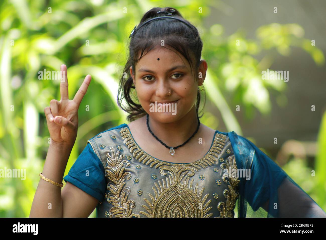 Indian Teenage Girl showing and pointing with finger number two while ...