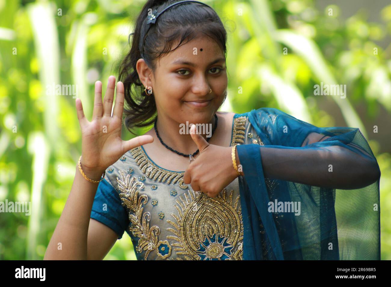 Indian Teenage Girl showing and pointing with finger number six while ...