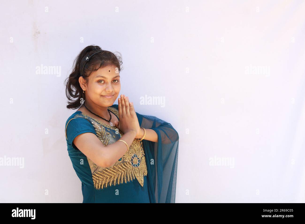 Beautiful Indian Rural girl laughing at a blank empty old concrete wall ...