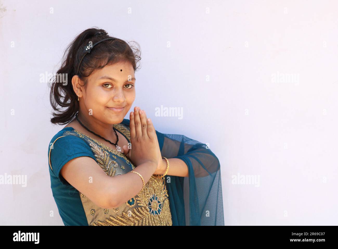 Beautiful Indian Rural girl laughing at a blank empty old concrete wall ...