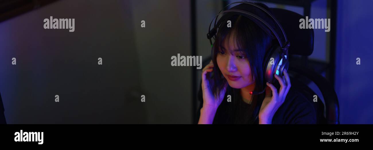 Female cyber hacker gamer in headphone watching video game on monitor ...