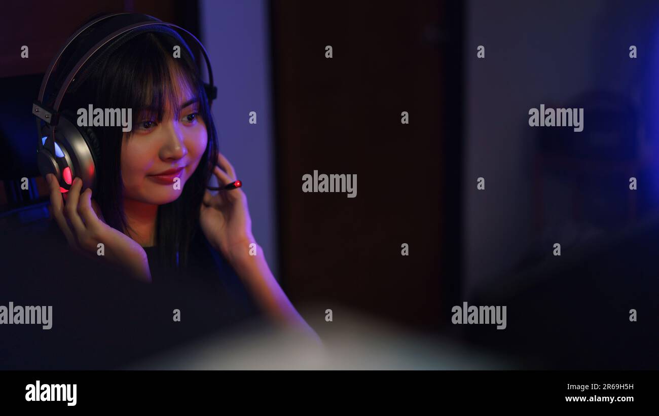 Female cyber hacker gamer in headphone watching video game on monitor ...