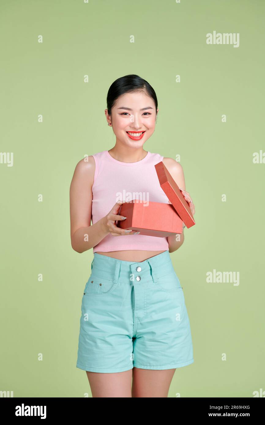 Emotional brunette young woman opens gift box, having overjoyed ...