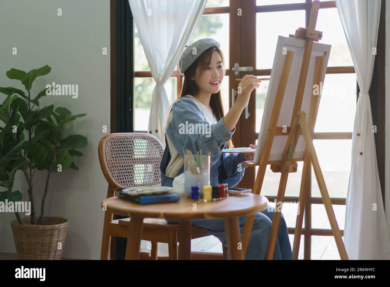 Young female artist creation to drawing and painting artwork on canvas ...