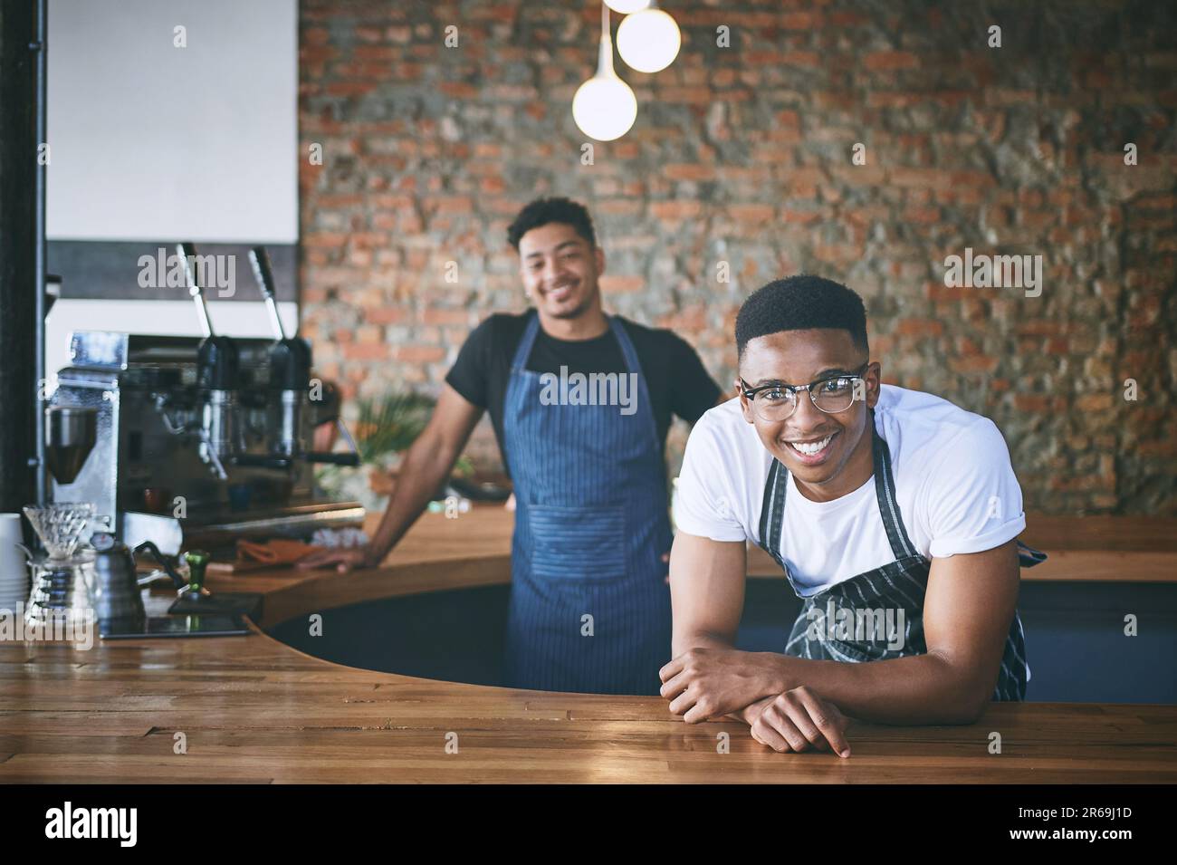 Happiness begins with brew. two confident young men working in a cafe ...
