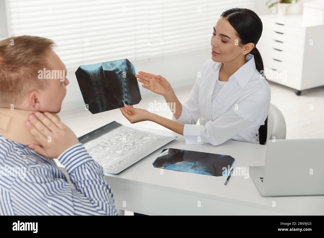 Doctor with neck MRI image consulting patient in clinic Stock Photo - Alamy
