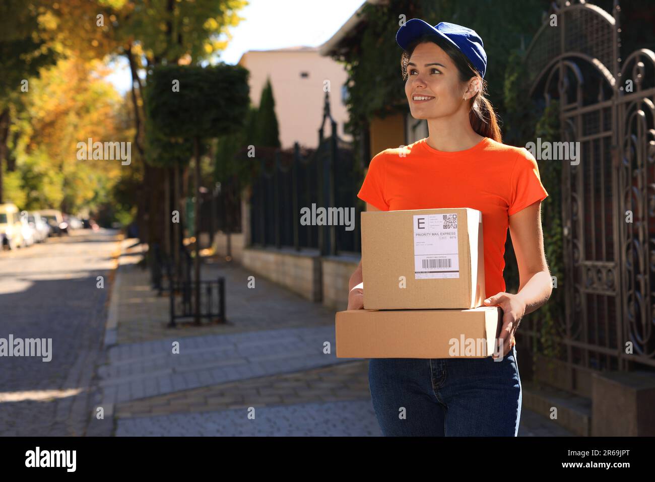Courier carrying cardboard boxes on city street Stock Photo - Alamy