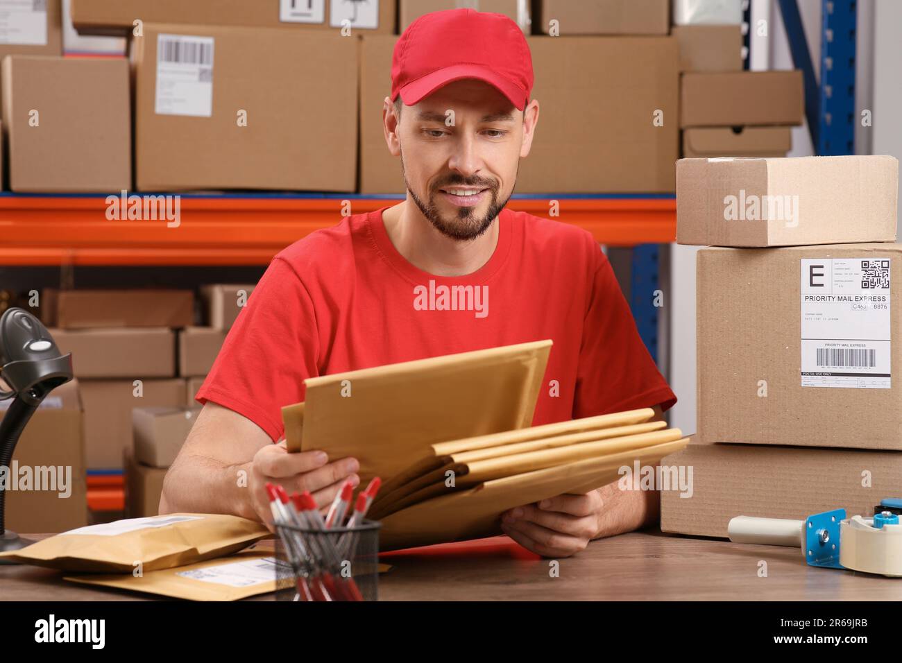 Post office worker with adhesive paper bags at counter indoors Stock ...