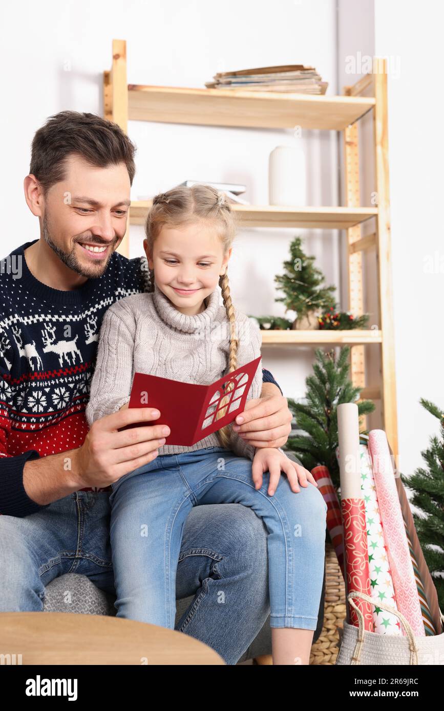 Happy man receiving greeting card from his daughter at home Stock Photo ...