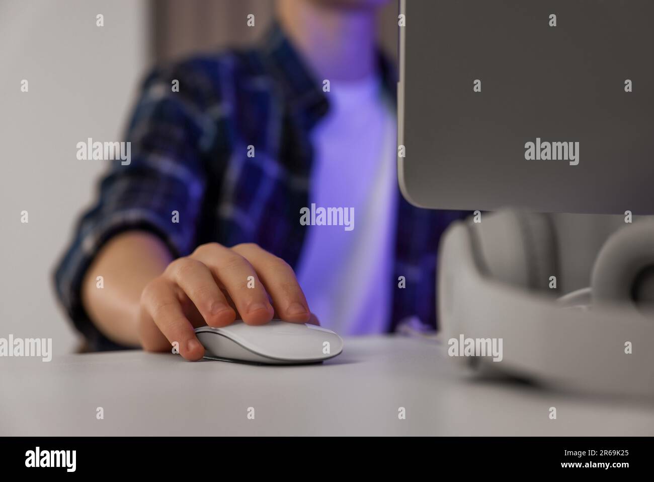 Teenage boy using computer in room at night, closeup. Internet ...