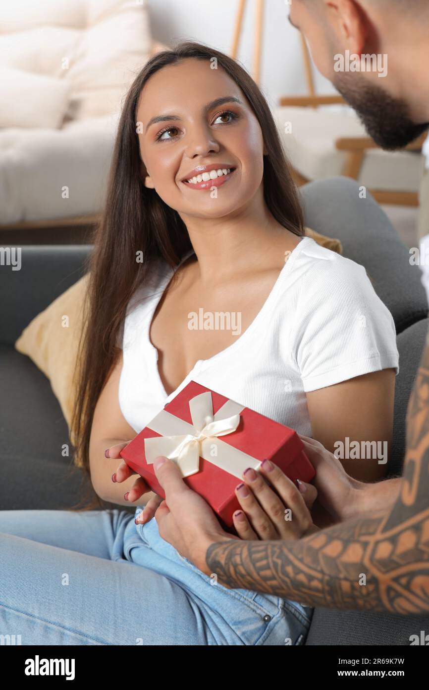 Woman receiving gift from her boyfriend at home Stock Photo - Alamy