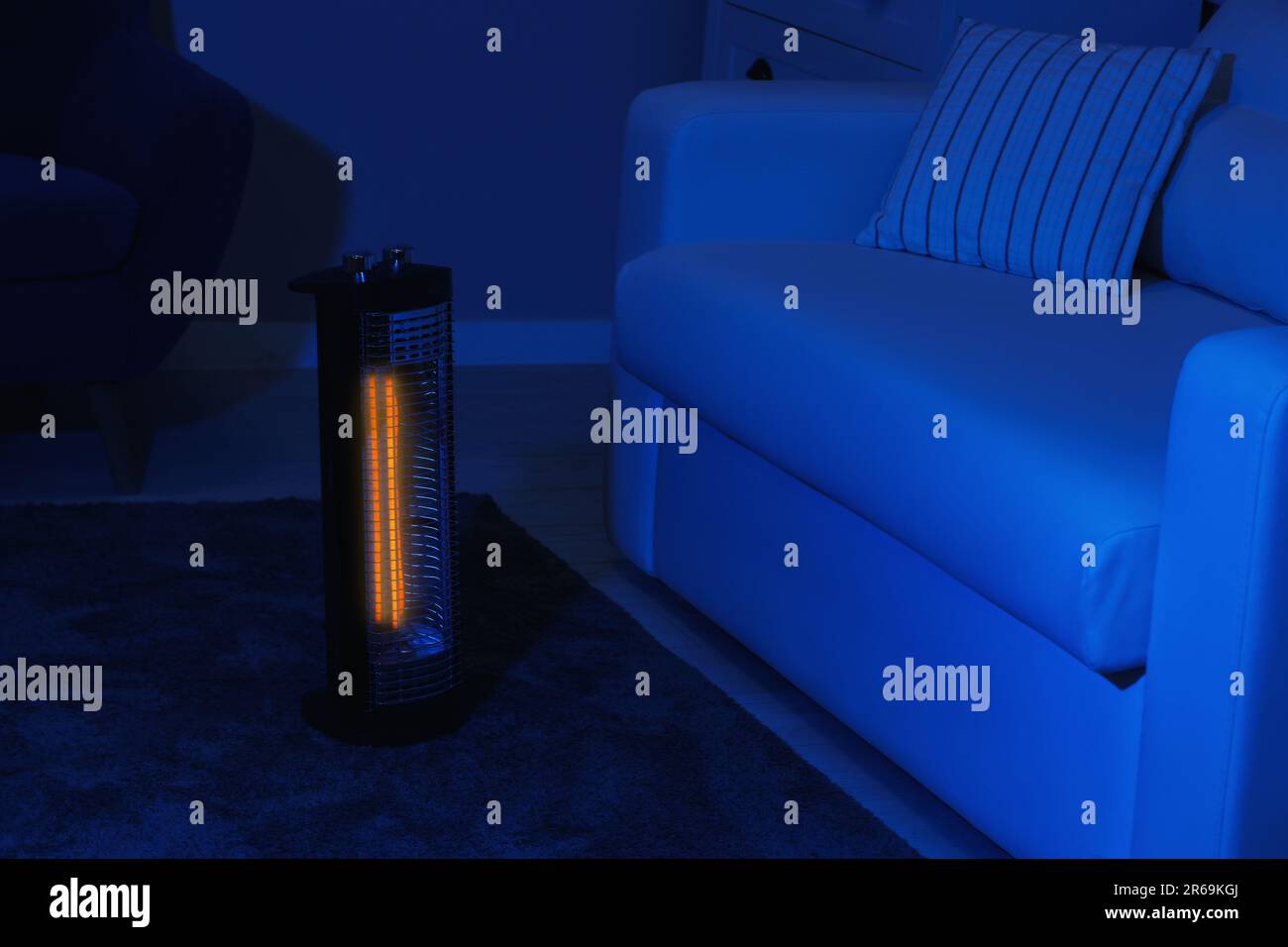 Electric infrared heater in dark living room at night Stock Photo - Alamy