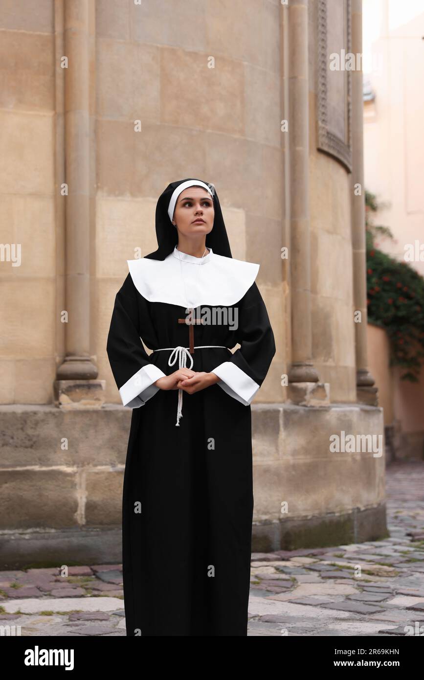 Young nun with Christian cross near building outdoors Stock Photo - Alamy