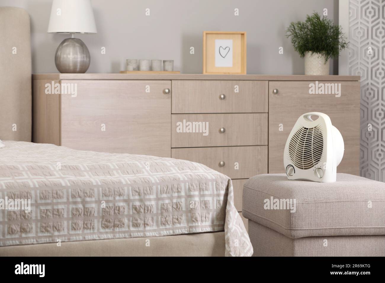 Modern electric fan heater on pouf in cozy room Stock Photo - Alamy