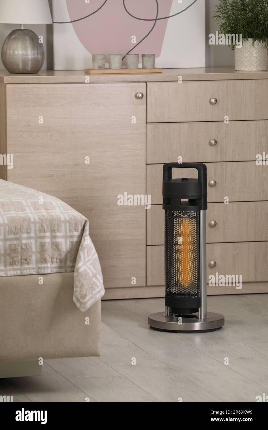 Modern infrared heater on floor in bedroom Stock Photo - Alamy