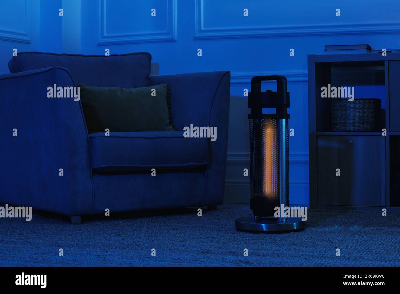 Electric infrared heater in dark living room at night Stock Photo - Alamy