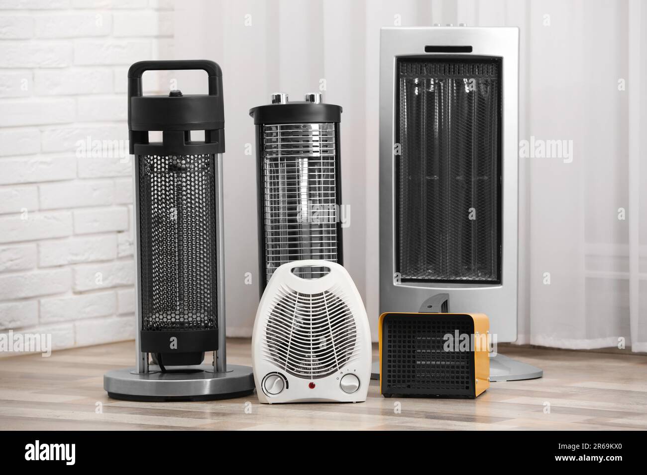 Different modern electric heaters on floor in room Stock Photo - Alamy
