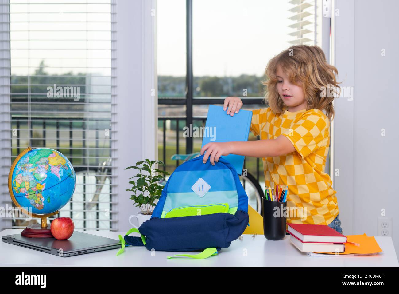 School kid student puts school supplies in a backpack. Preparation for ...