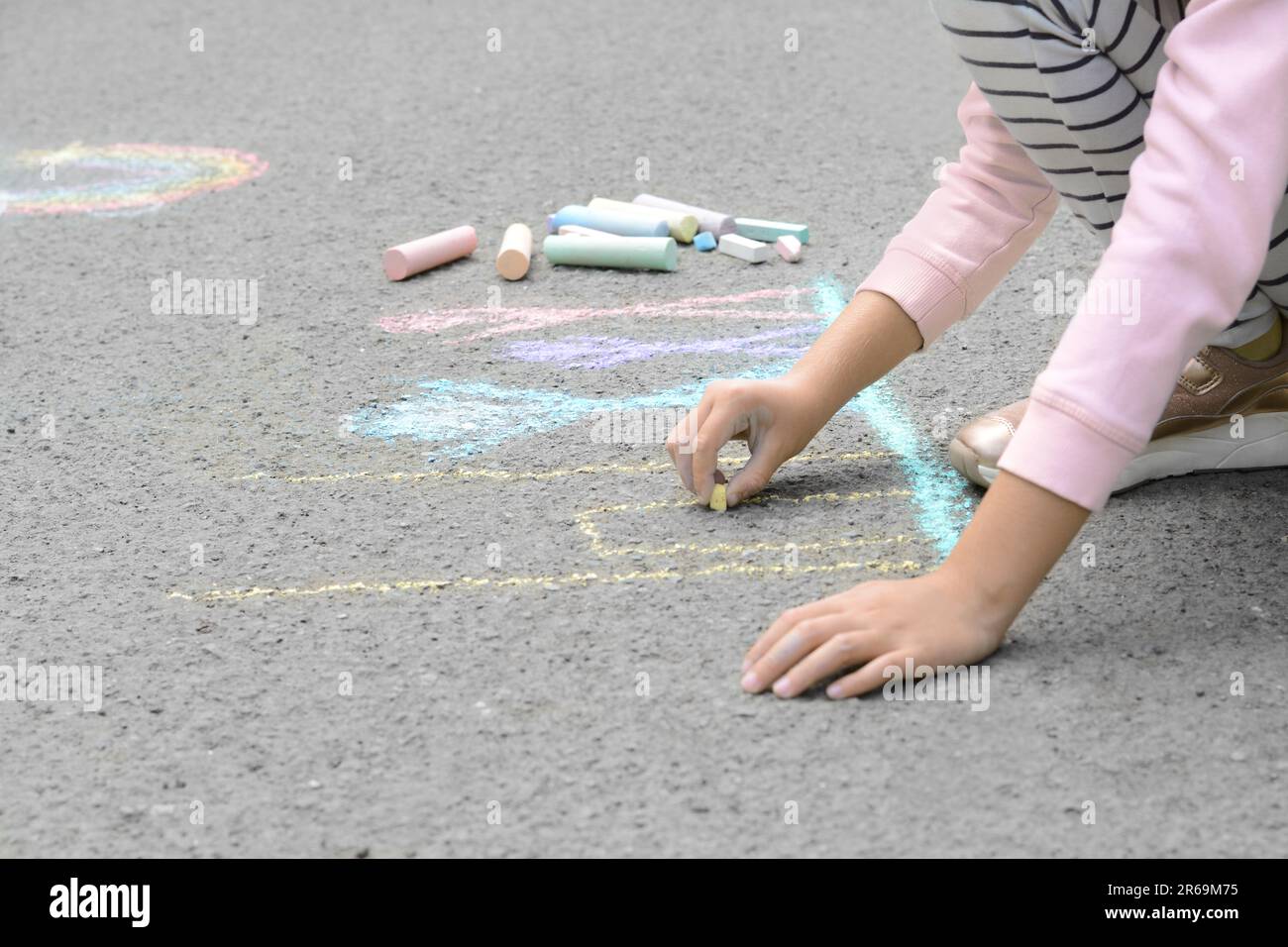 Little child drawing happy family with chalk on asphalt, closeup Stock ...