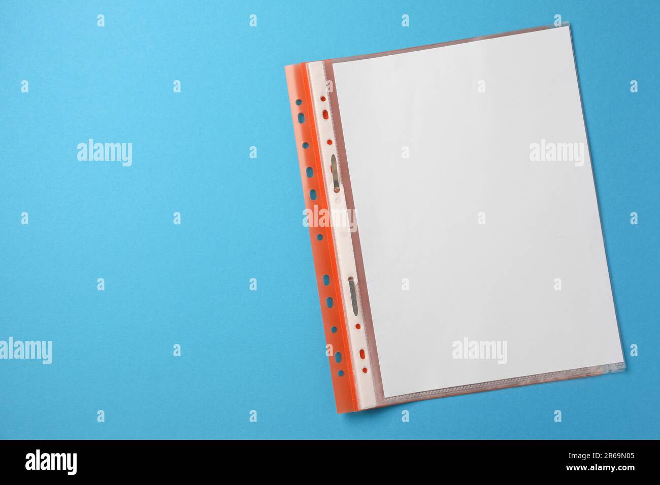 File folder with punched pockets on light blue background, top view ...