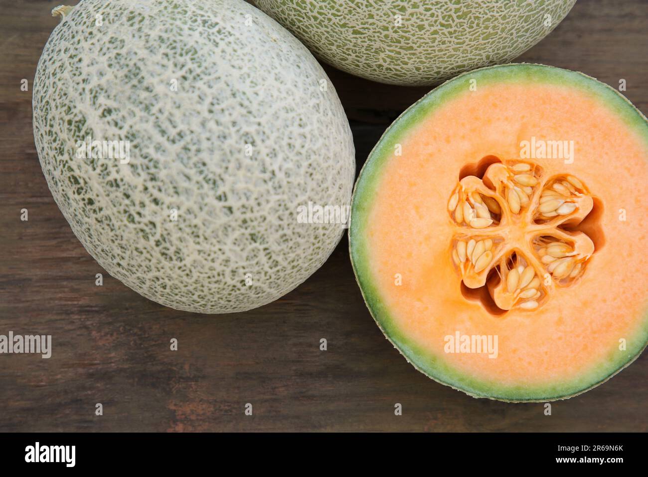 Whole and cut fresh ripe melons on wooden table, flat lay Stock Photo ...