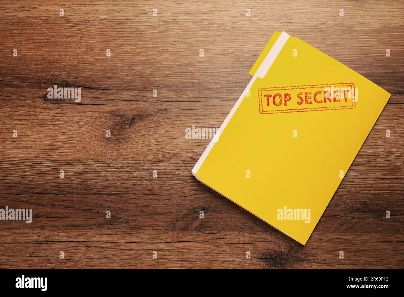 Yellow file with documents and Top Secret stamp on wooden table, top ...