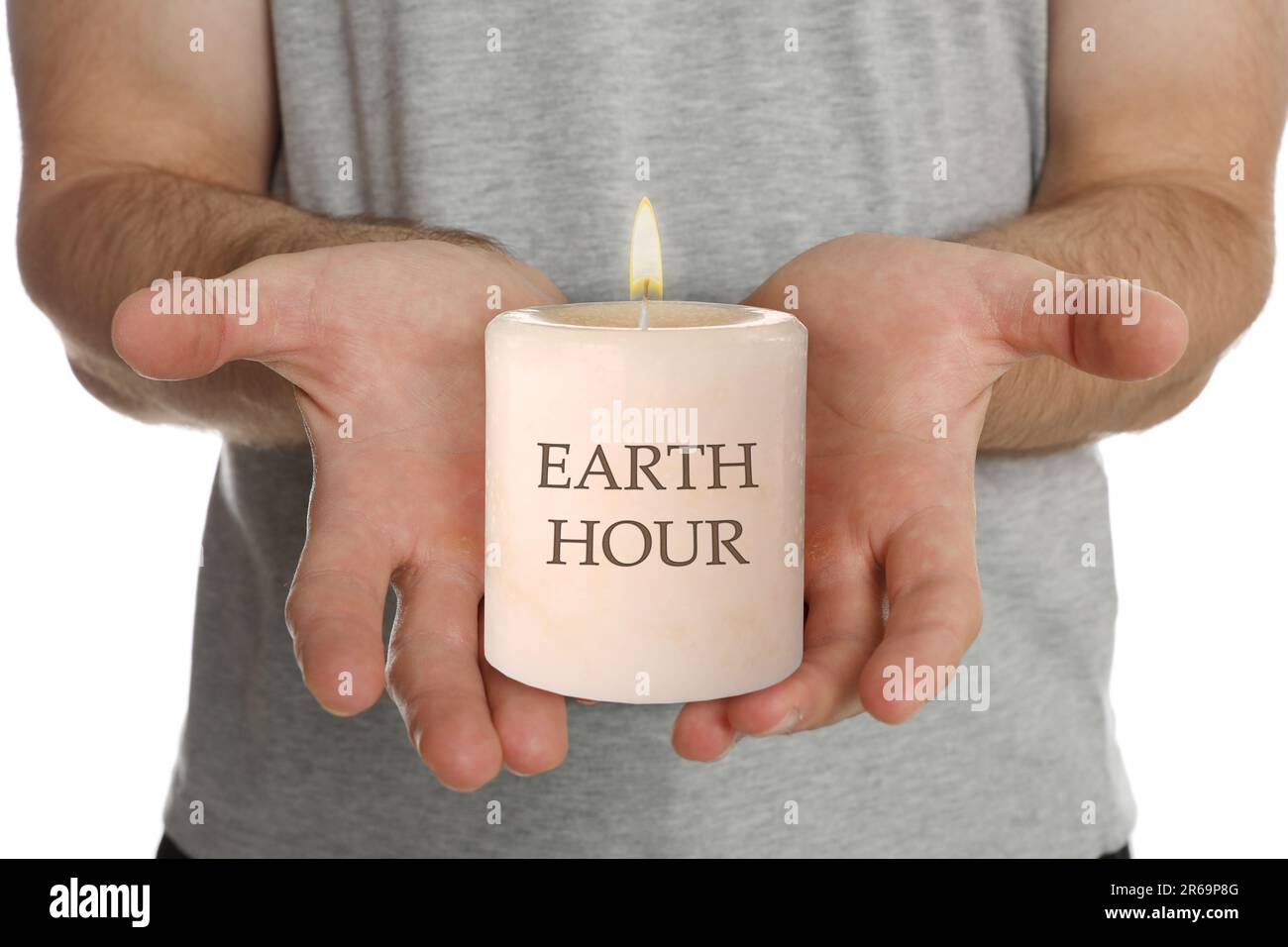 Turn off lights for Earth hour. Man holding burning candle on white ...