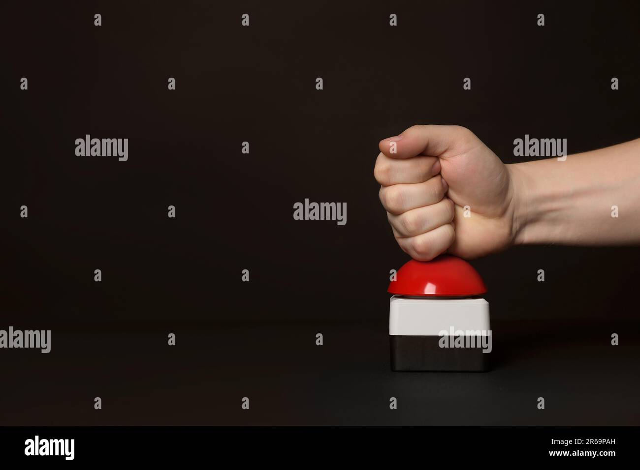 Man pressing red button of nuclear weapon at black background, closeup ...