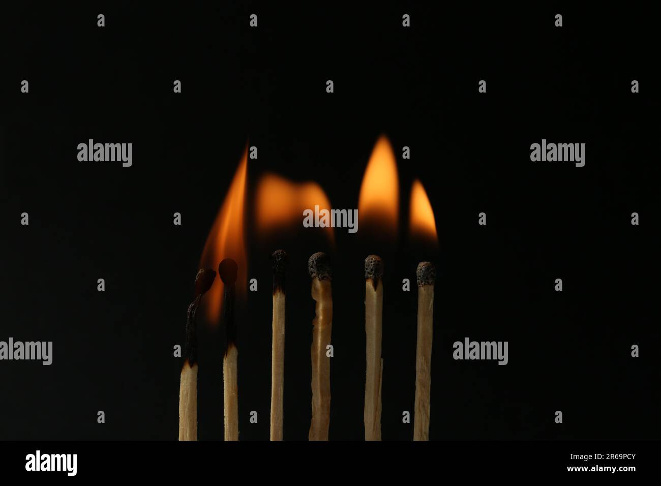Line of burning matches on black background Stock Photo - Alamy