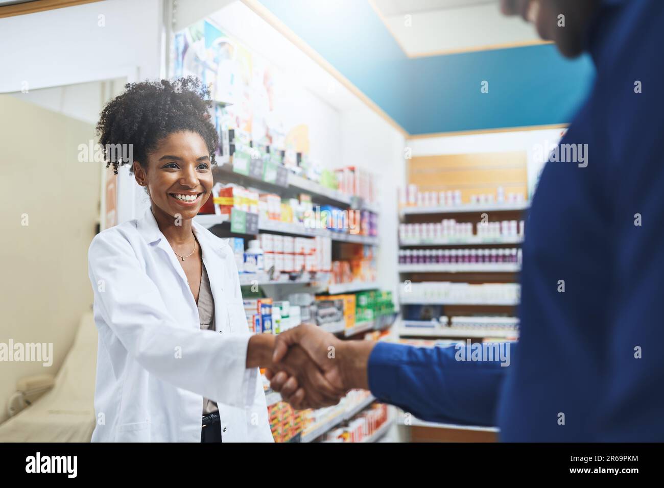 Thank you for visiting my pharmacy. a pharmacist and a customer shaking ...