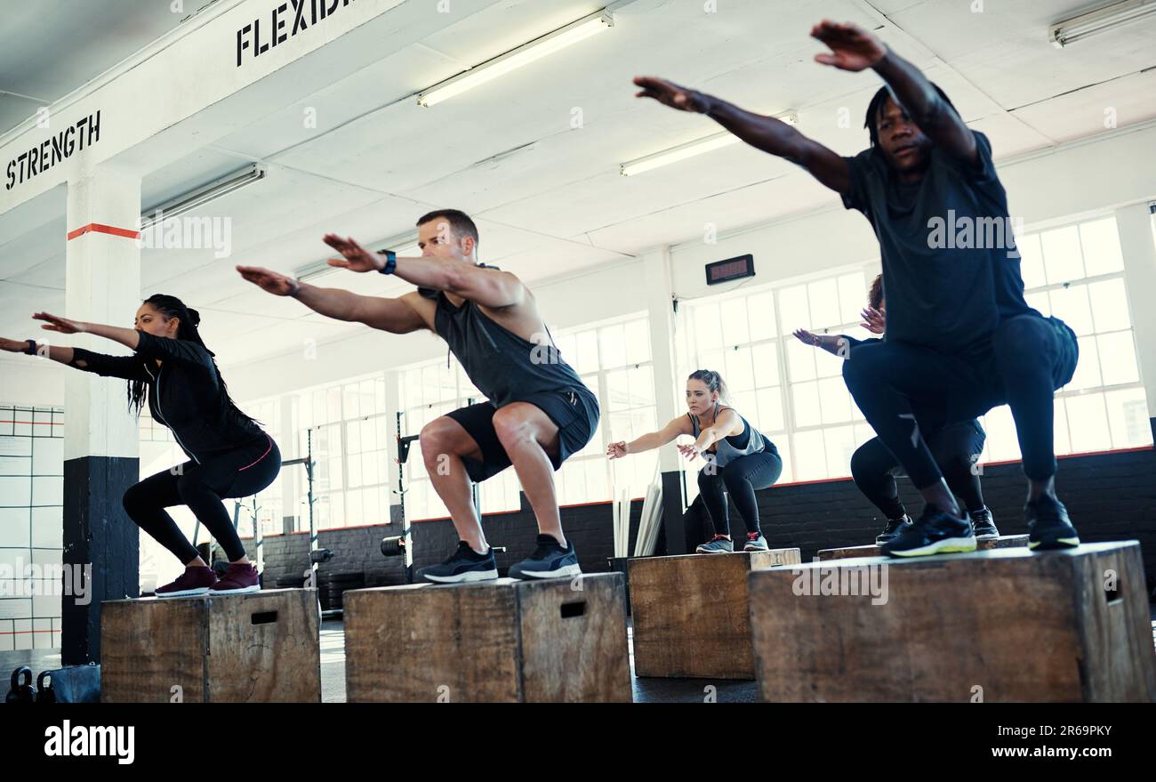 Keep your balance. a focused group of young people doing lunges on ...