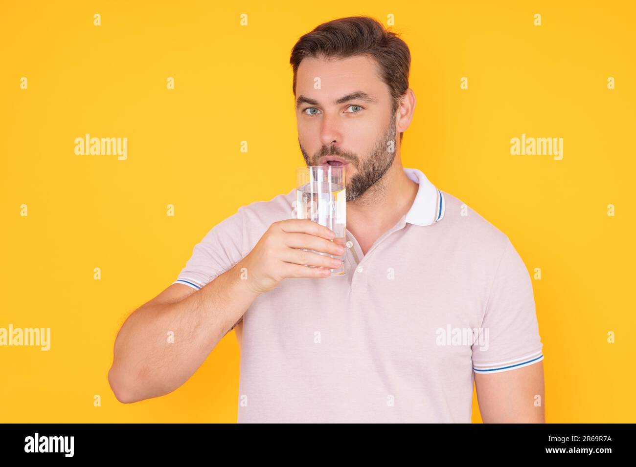 Man drinking a fresh glass of water. Thirsty man holding glass drinks ...