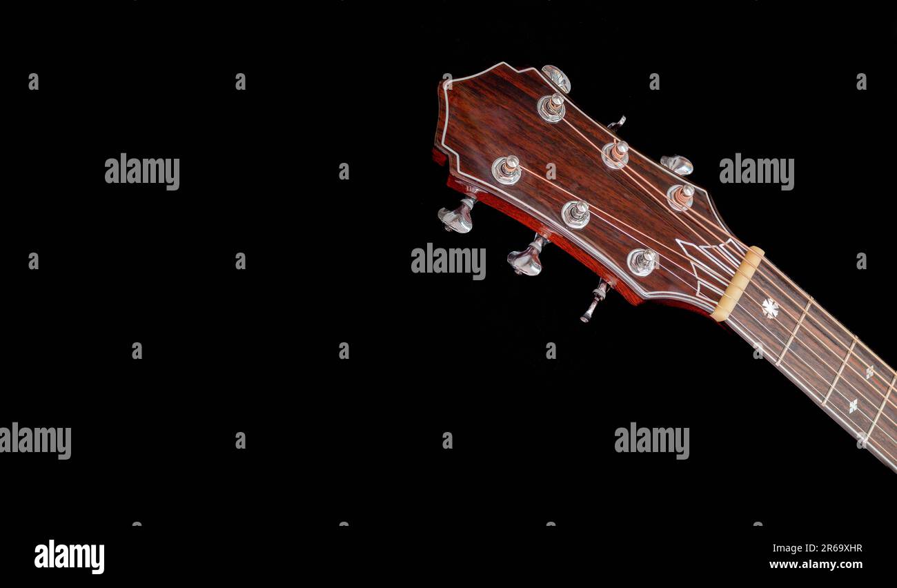 The neck of a six-string acoustic guitar on a dark background . guitar ...