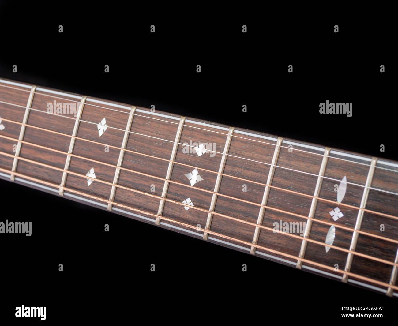 The neck of a six-string acoustic guitar on a dark background . guitar ...