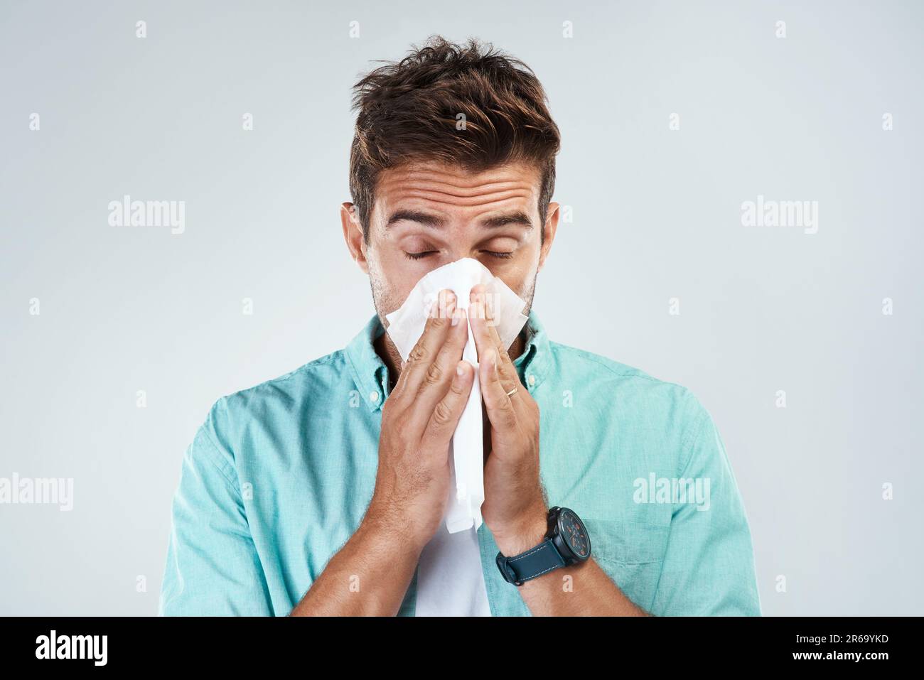 Sick, tissue and face of man blowing nose in studio with flu, illness ...