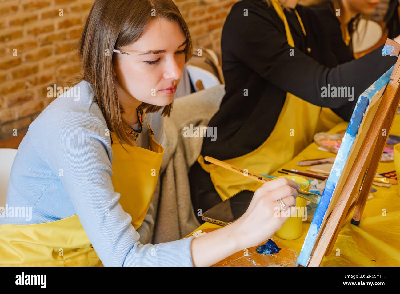 Woman paint brush canvas friends hi-res stock photography and images ...