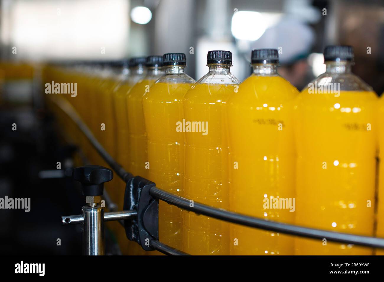 A row of plastic bottles being filled with liquid Stock Photo - Alamy