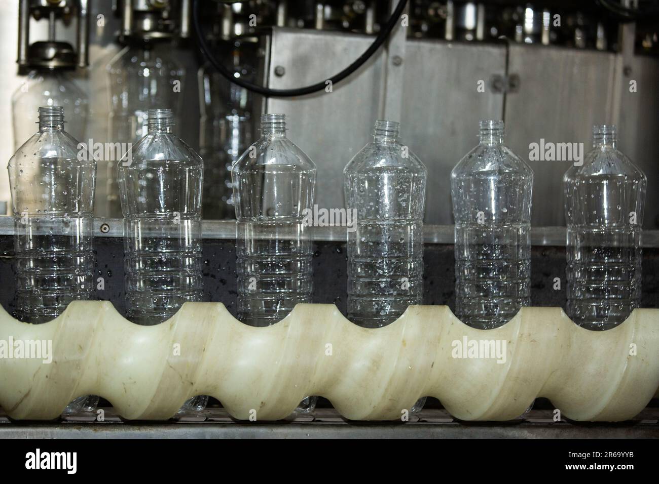 A row of plastic bottles being filled with liquid Stock Photo - Alamy